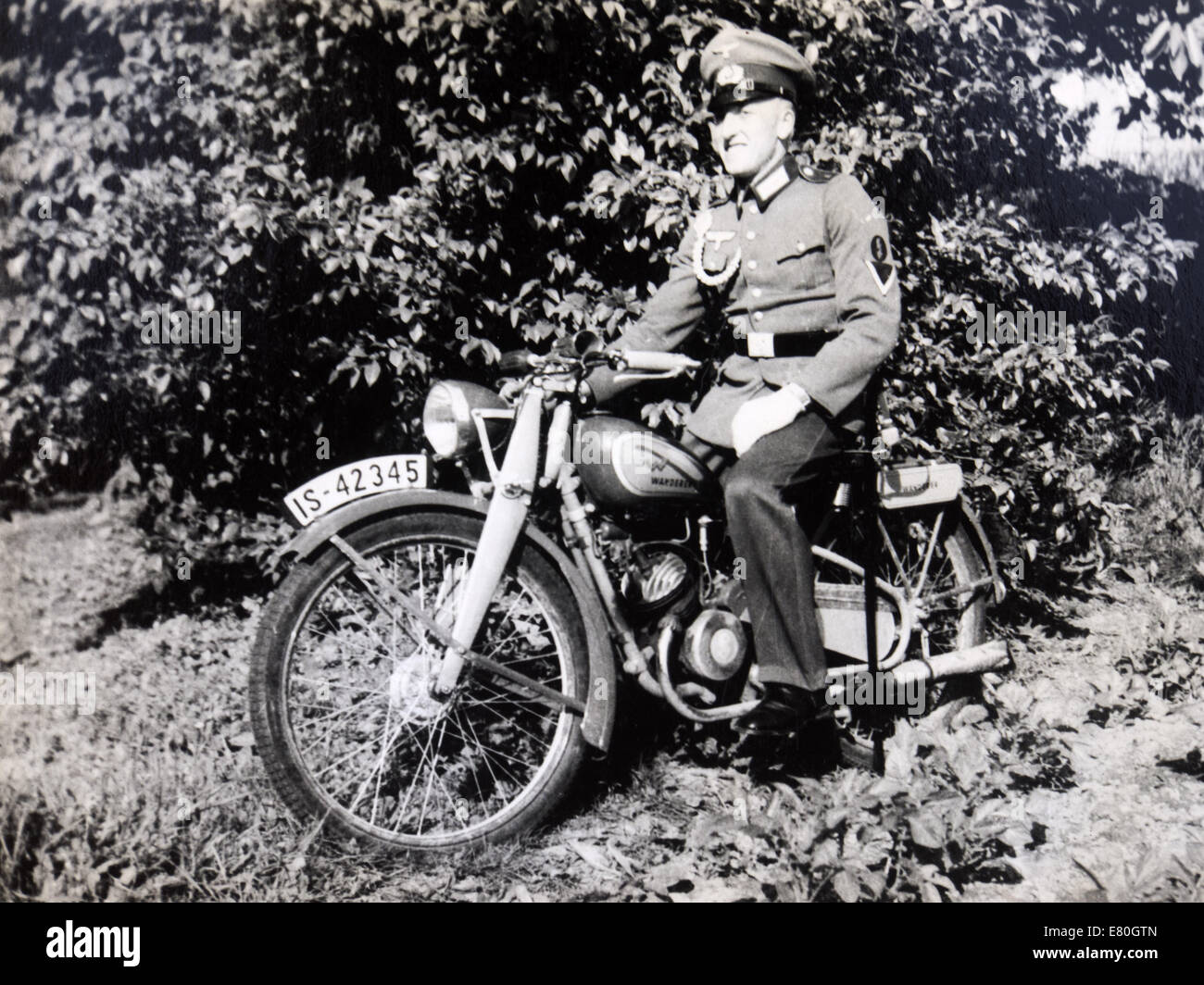German oficer posing on a motorcycle, Germany, 1940s. Reproduction of ...