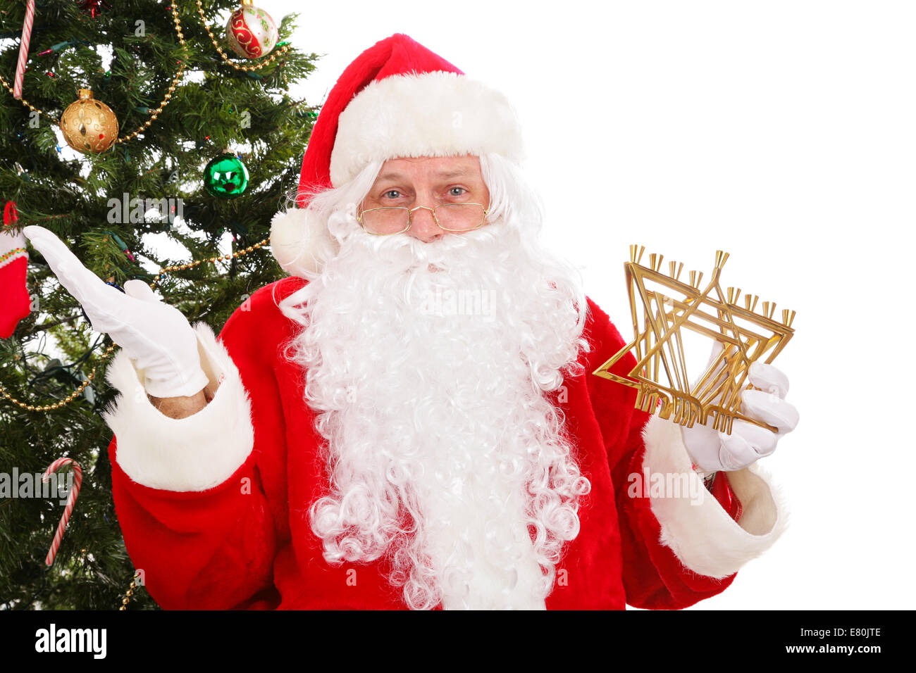 Santa standing in front of a Christmas tree holding a menorah Stock ...