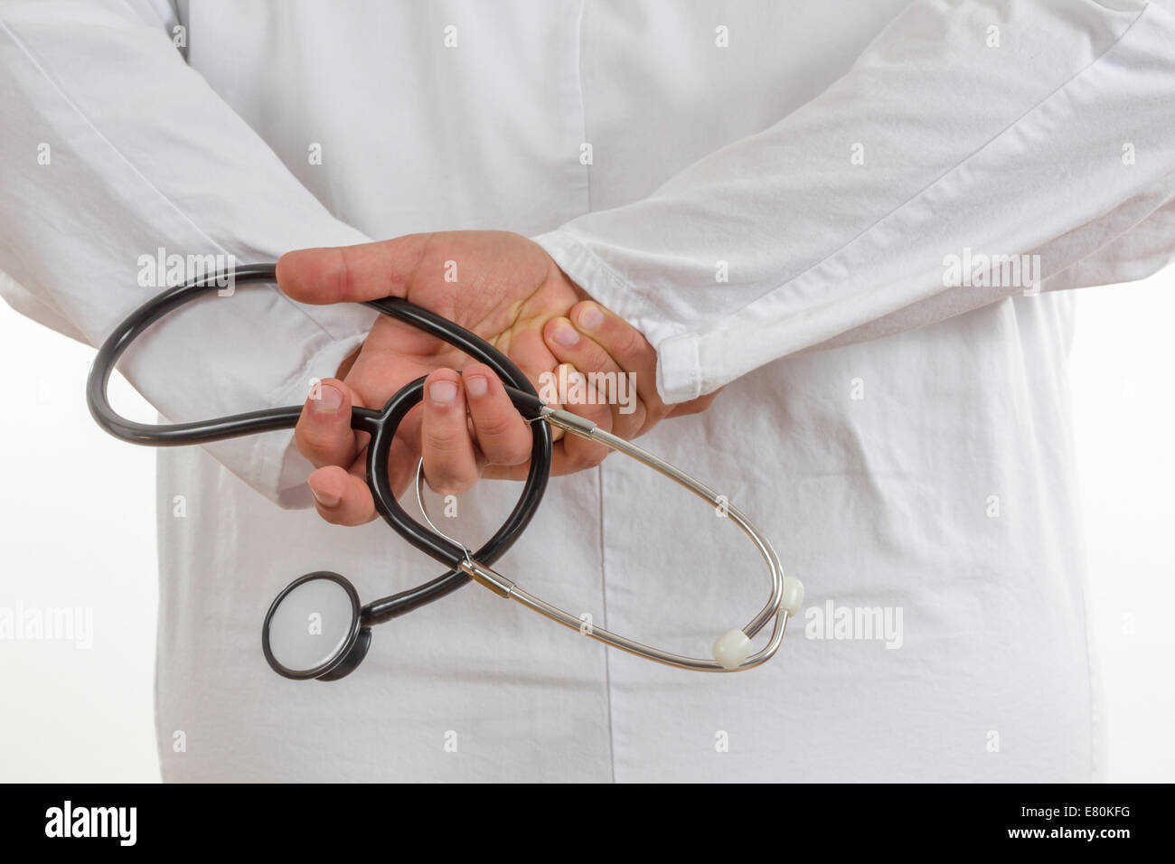 Doctor holding his stethoscope on his back isolated on white background ...