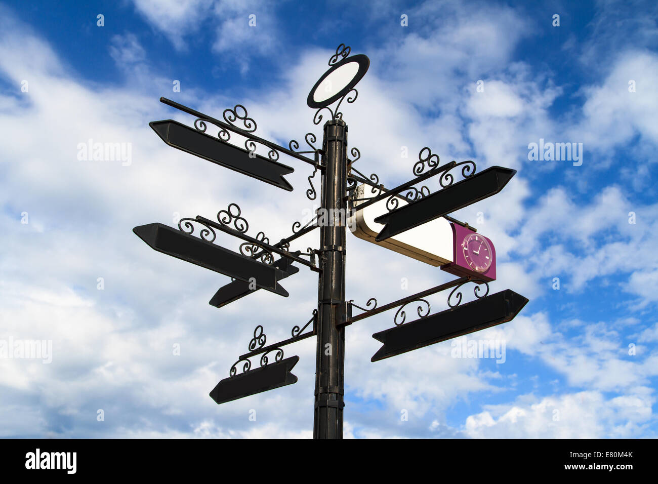 Blank, black crossroad signs, different directions, on cloudy blue ...