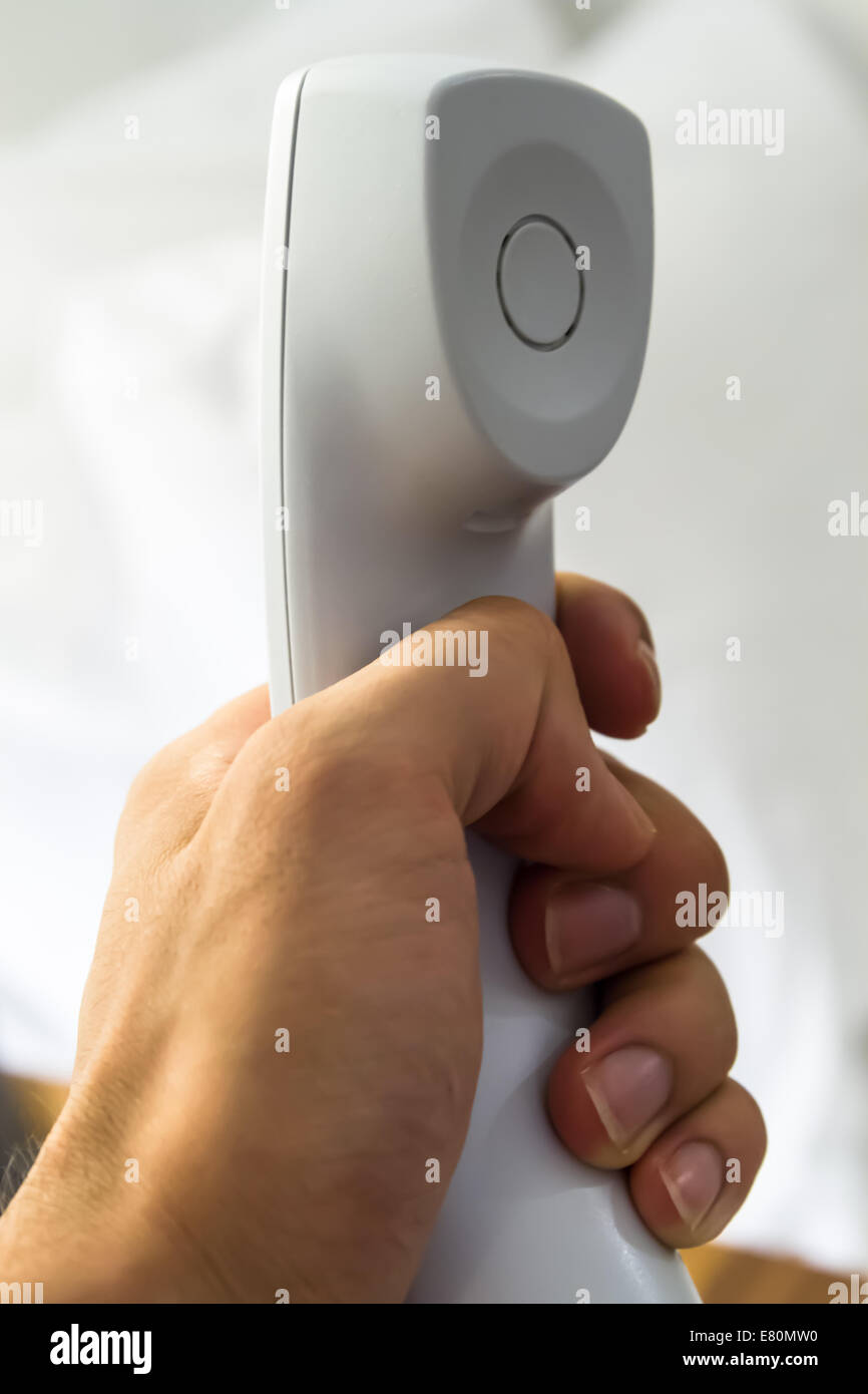 Hand holding white telephone tube in hotel room Stock Photo - Alamy