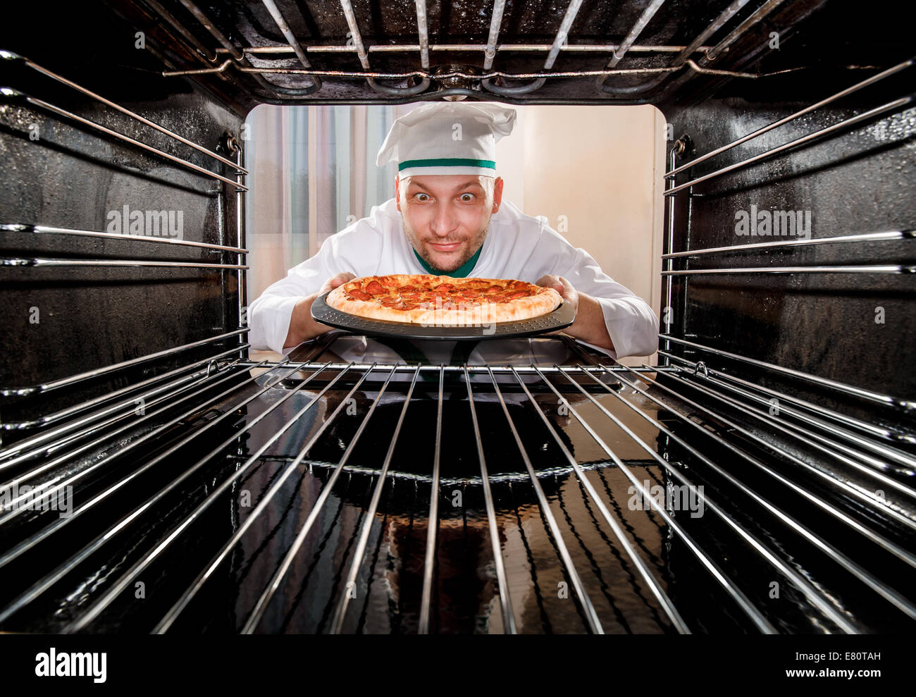 Chef prepares pizza in the oven, view from the inside of the oven ...