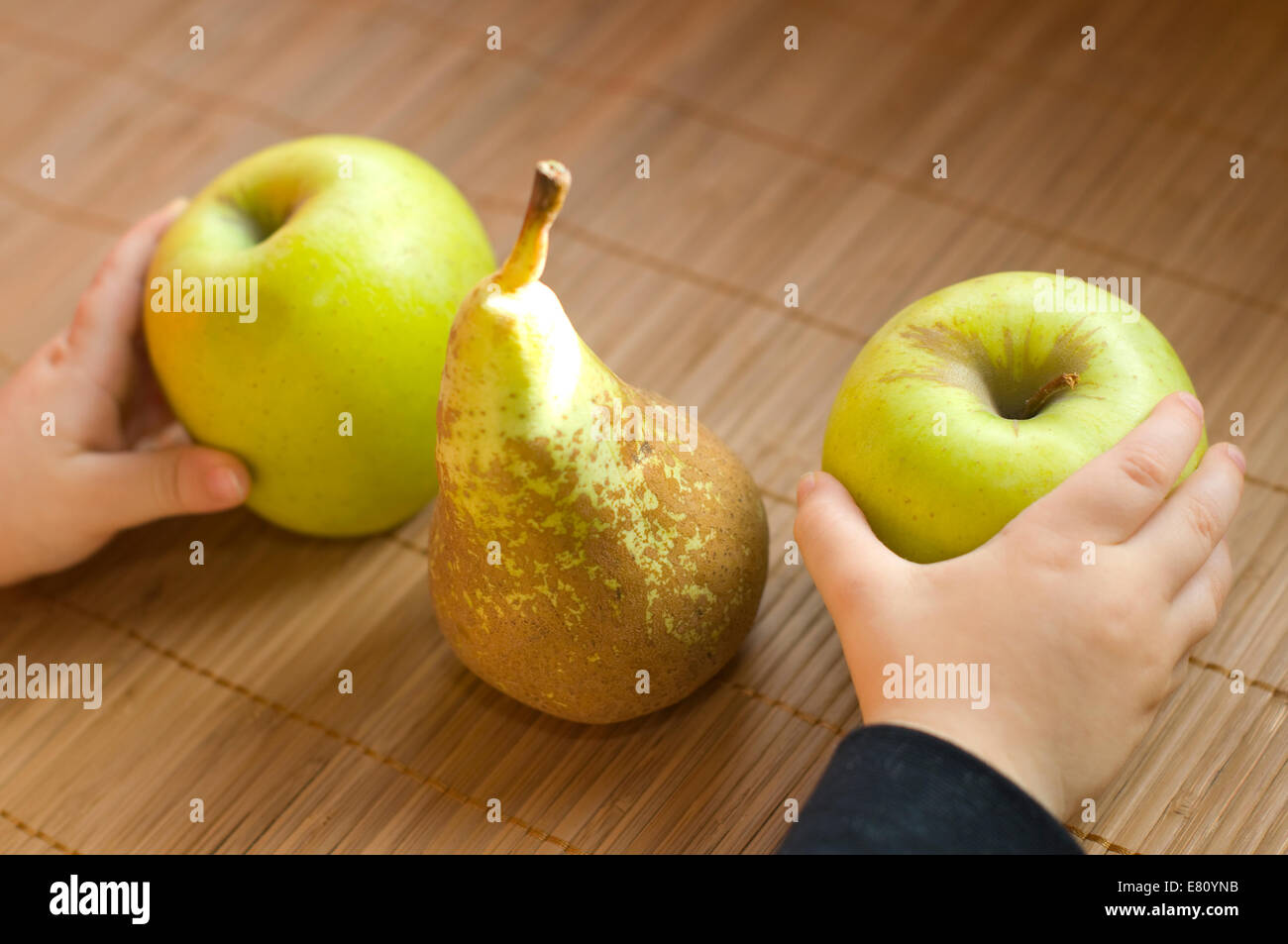 Baby hands catching two apples from the table Stock Photo - Alamy