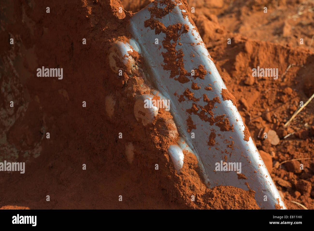 The side of an excavator bucket is covered in clots of dirt after ...