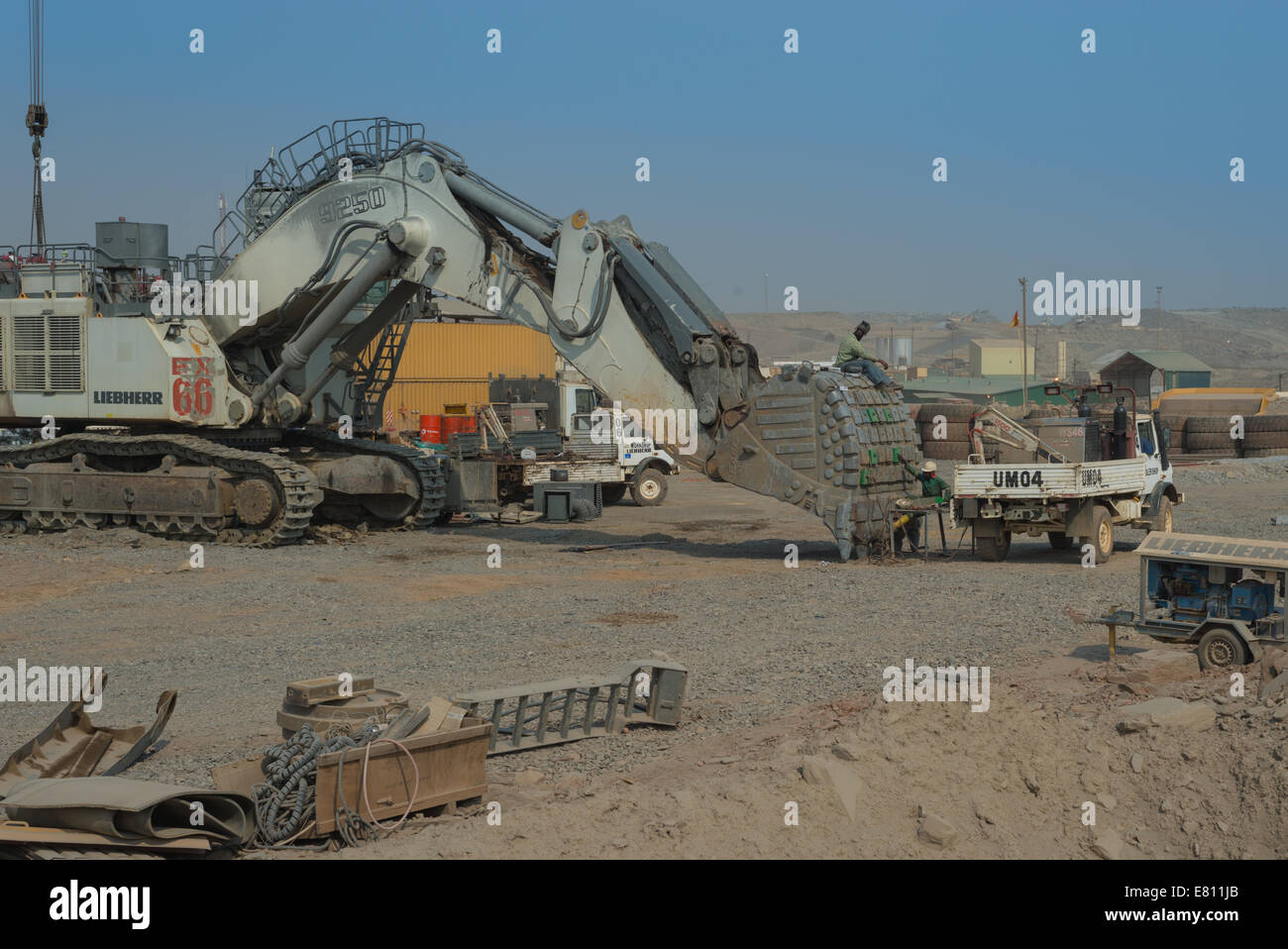 Two African mine workers repair and replace wear pads and teeth on a ...