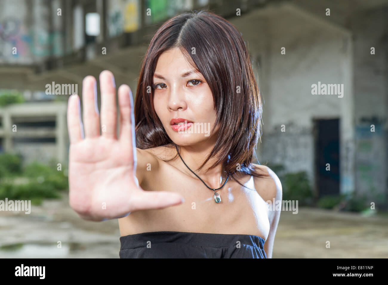 Chinese woman showing no hand gesture with old bulding in background ...