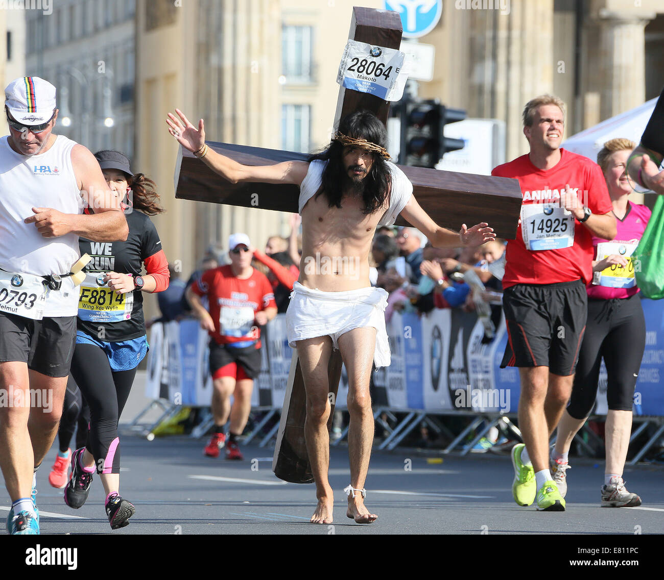 Berlin, Germany. 28th Sep, 2014. With a cross on his back and barefoot ...