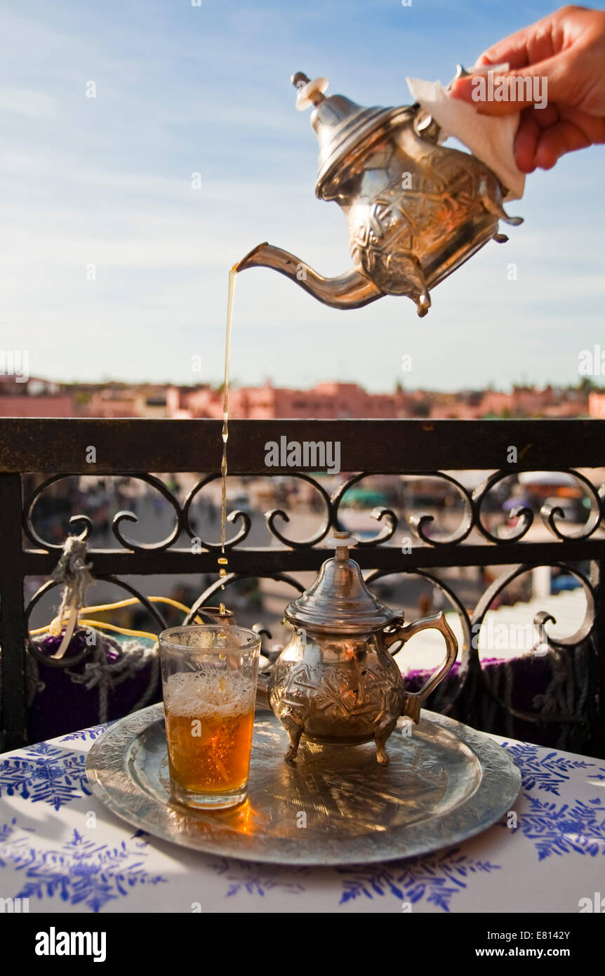 Vertical close up of traditional mint tea poured from a height into ...
