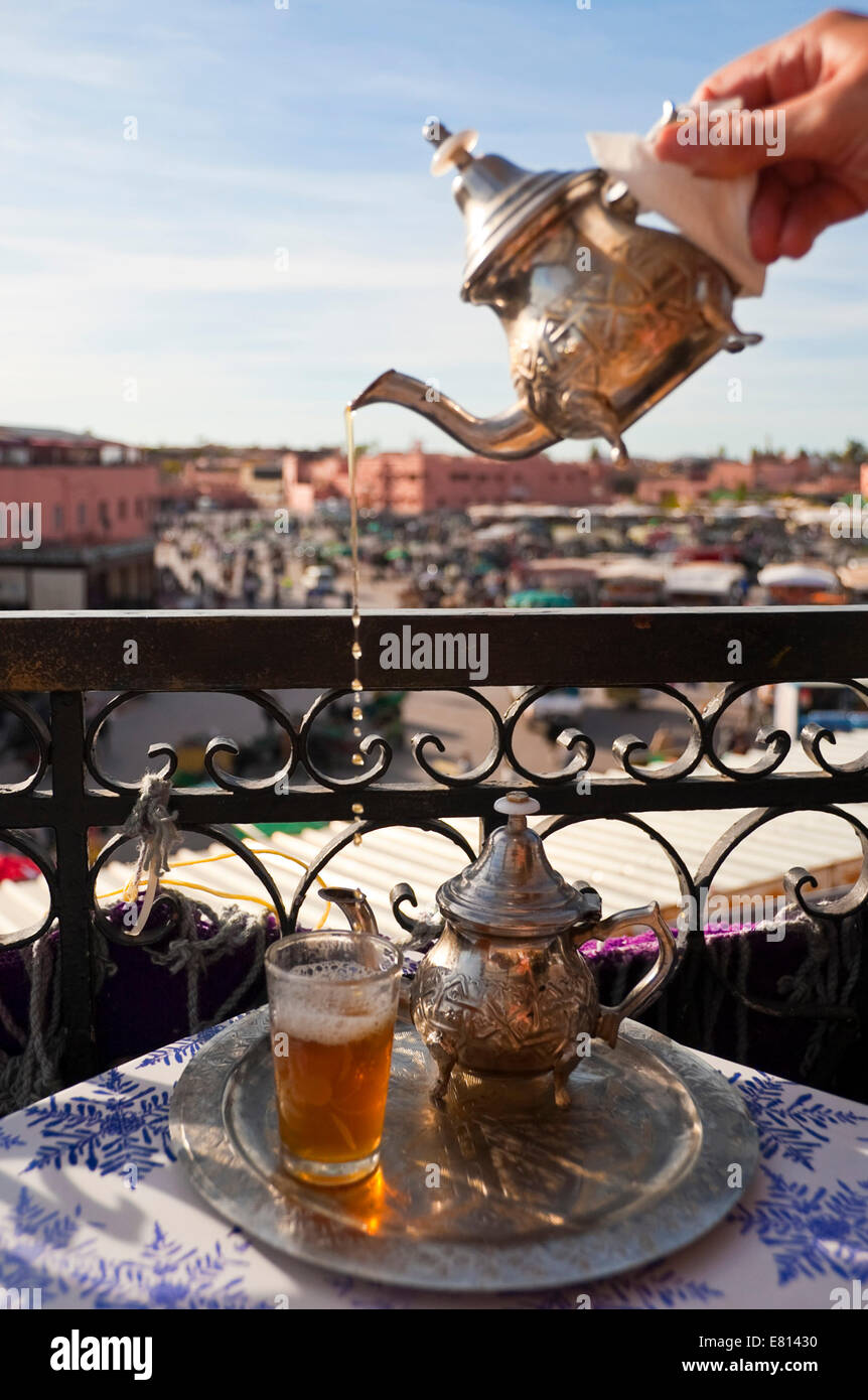 Vertical close up of traditional mint tea poured from a height into ...
