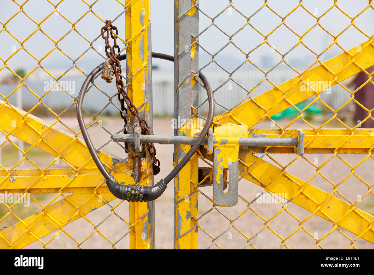 Metal chain and lock on yellow background Stock Photo - Alamy