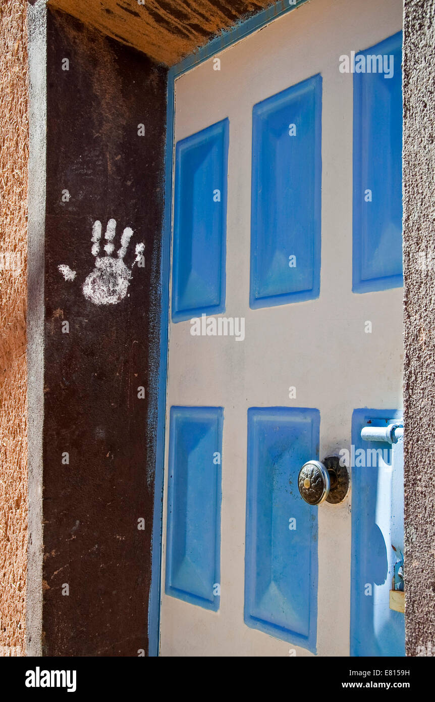 Vertical view of a front door with the owners hand imprint on the wall ...