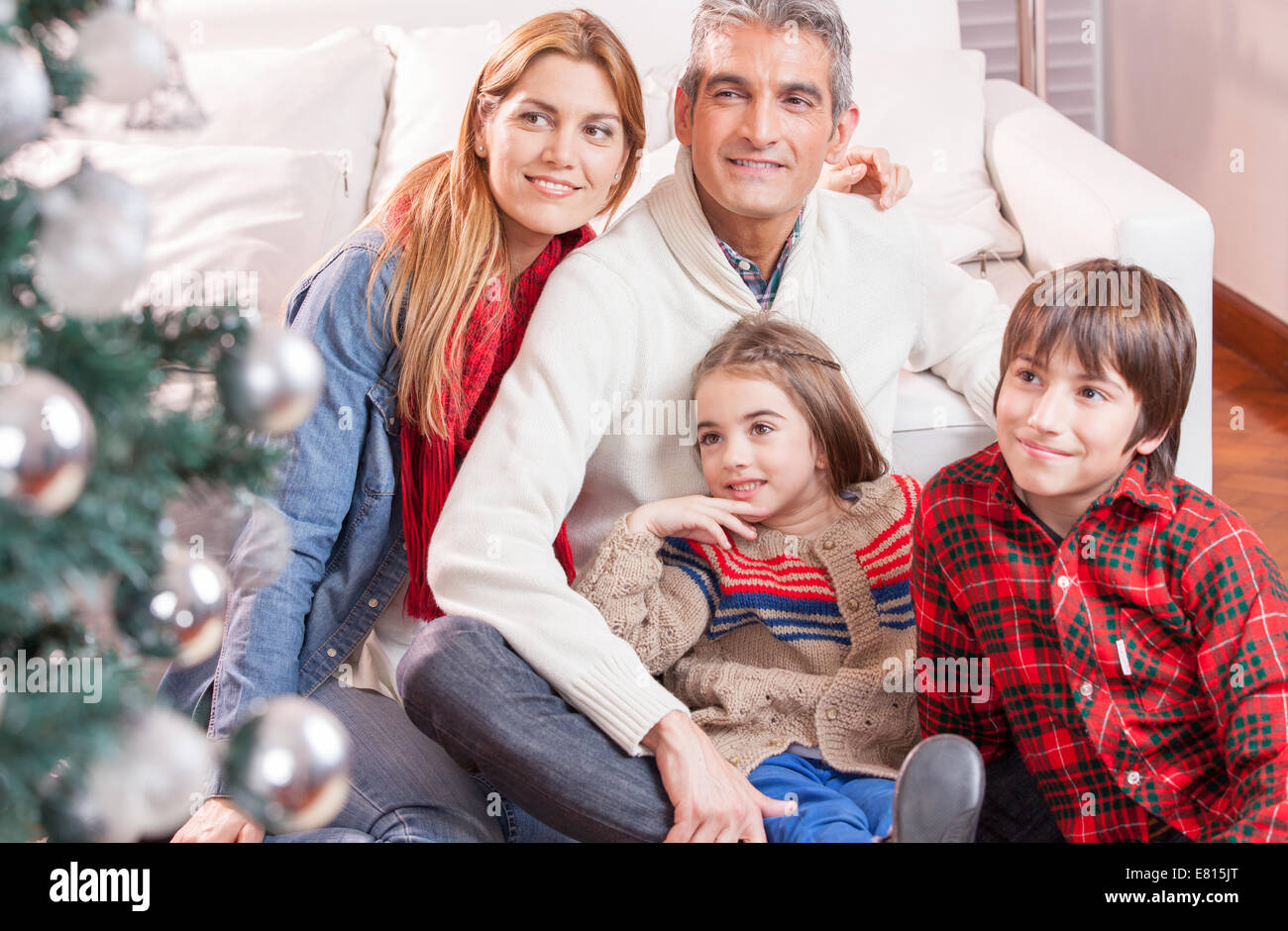 Happy family enjoying Christmas tree Stock Photo - Alamy