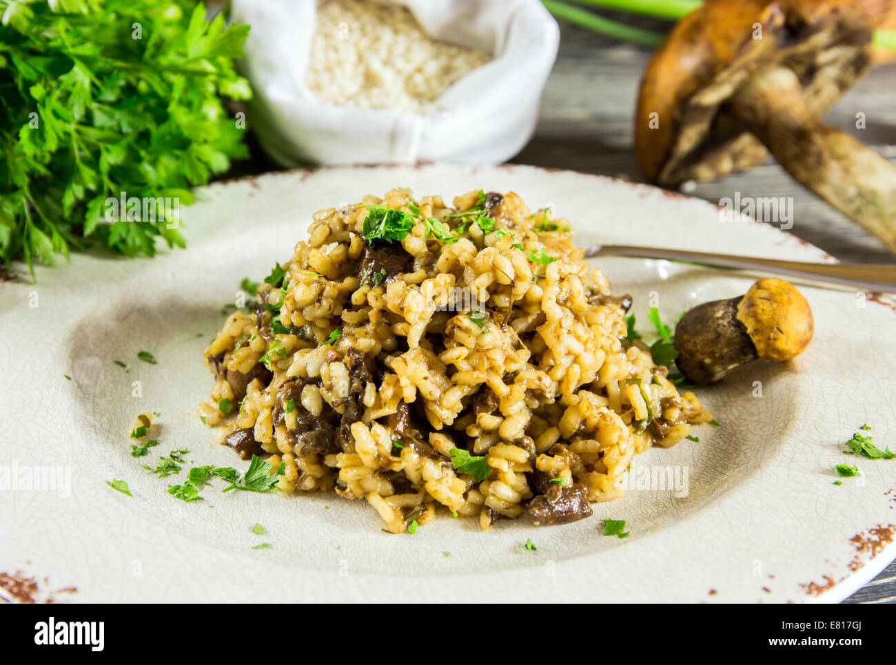 Italian risotto with mushrooms arranged on a wooden table Stock Photo ...