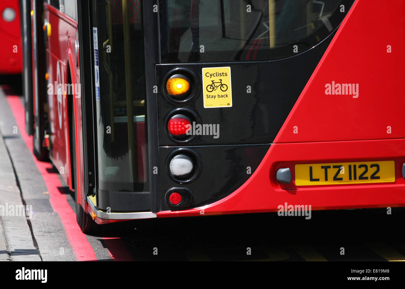 A rear view of parts of two red London buses traveling in London Stock ...