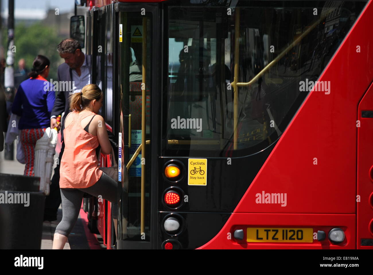 People boarding or exiting red London buses parked at a bus stop Stock ...