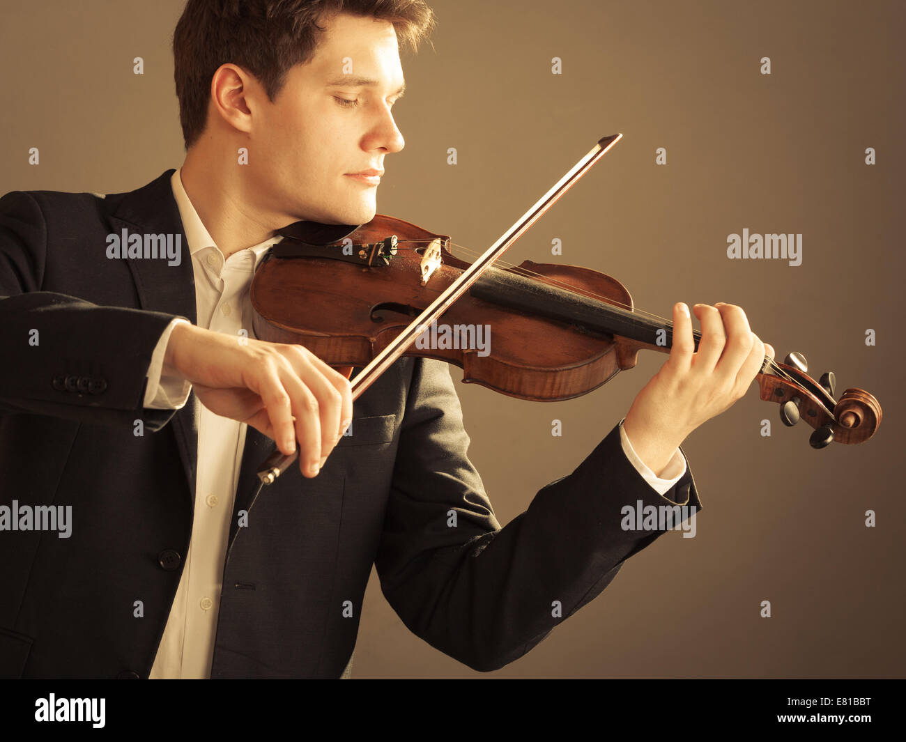 Art and artist. Young elegant man violinist fiddler playing violin on ...