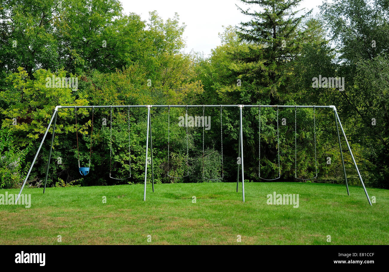 Kids swingset in park Stock Photo - Alamy