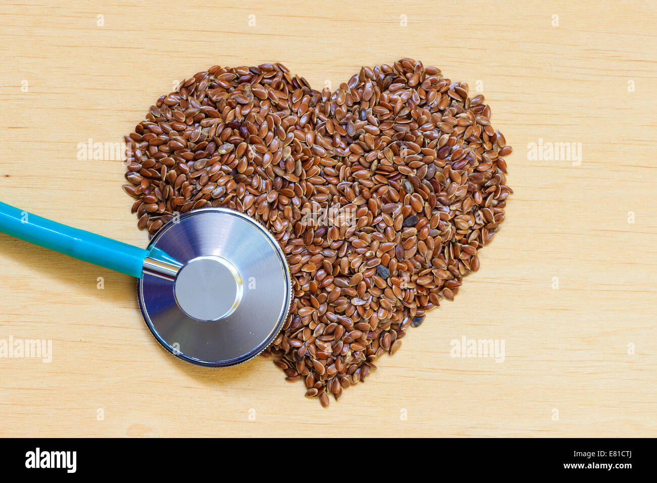 Diet healthcare and checkup concept. Raw flax seeds linseed heart shaped and stethoscope ...
