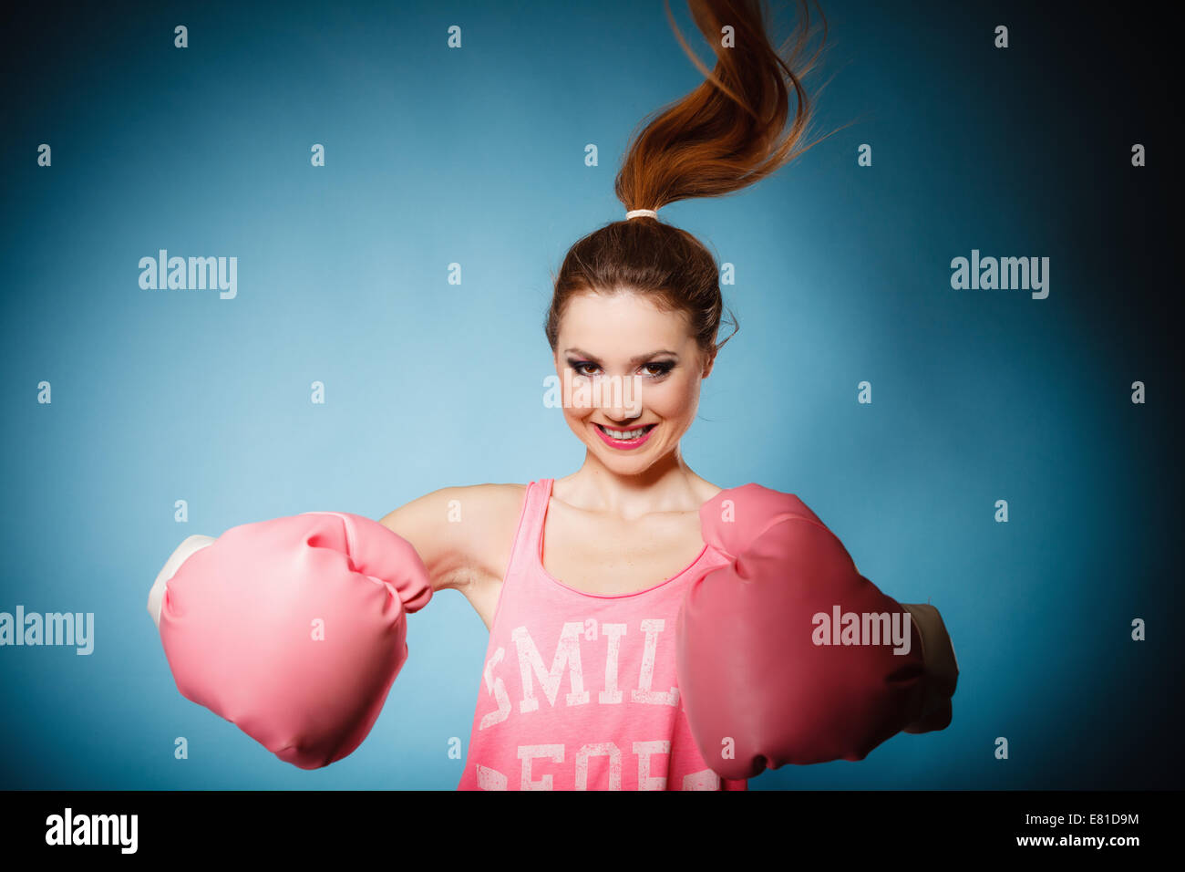 Funny girl female boxer in big fun pink gloves playing sports boxing ...