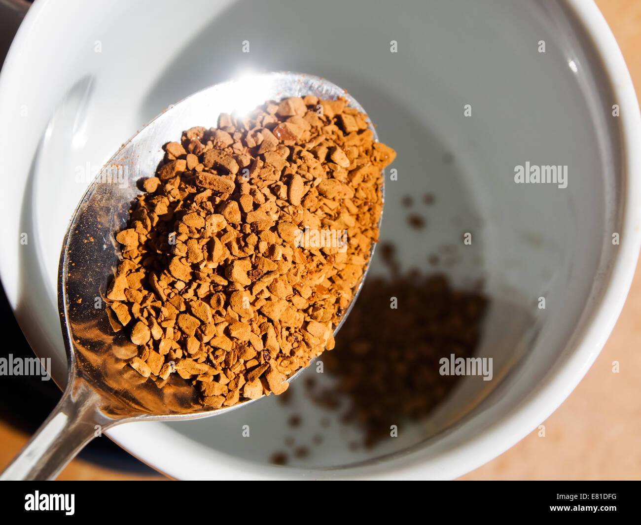 Instant coffee granules on a teaspoon, being poured into a mug Stock ...
