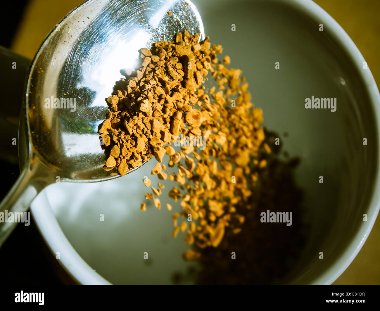Instant coffee granules on a teaspoon, being poured into a mug Stock ...