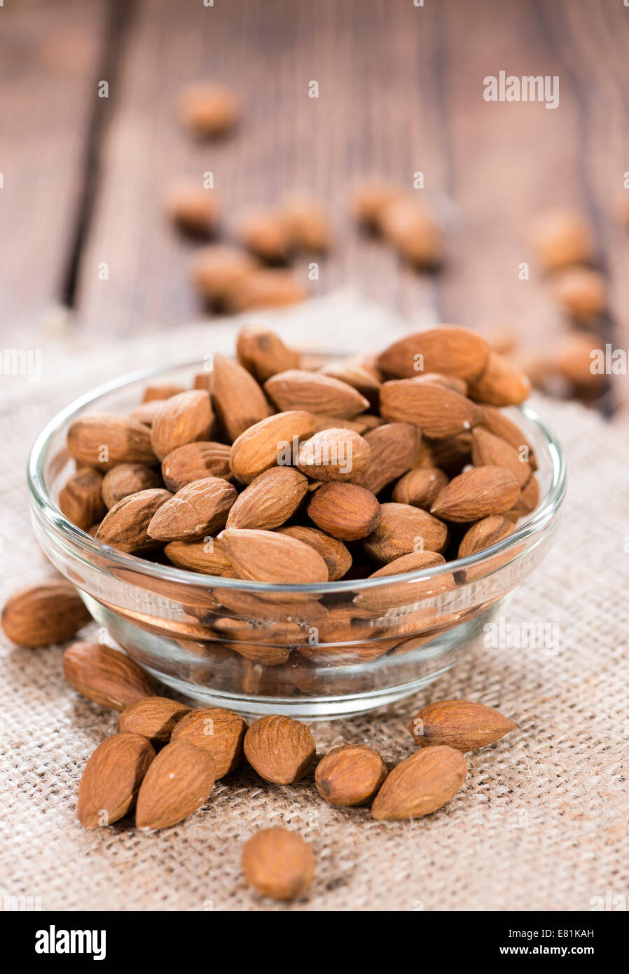 Almonds (detailed close-up shot) on wooden background Stock Photo - Alamy
