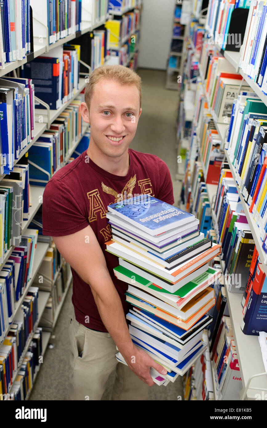 Student carrying a stack of books in the Departmental Library of the ...