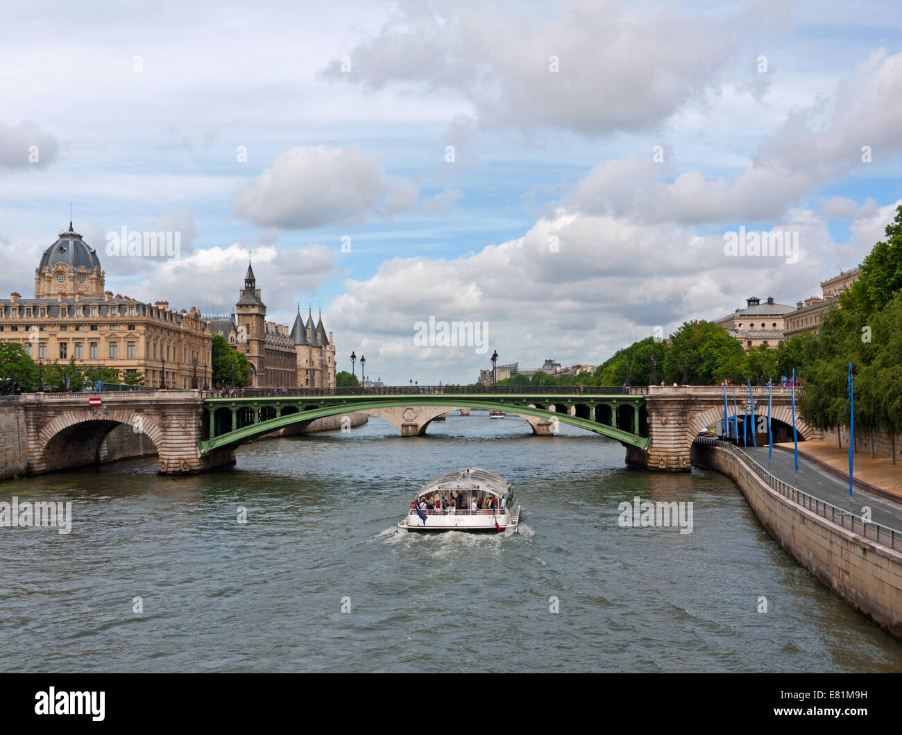 View of the Seine river with the Notre-Dame bridge and a tour boat ...