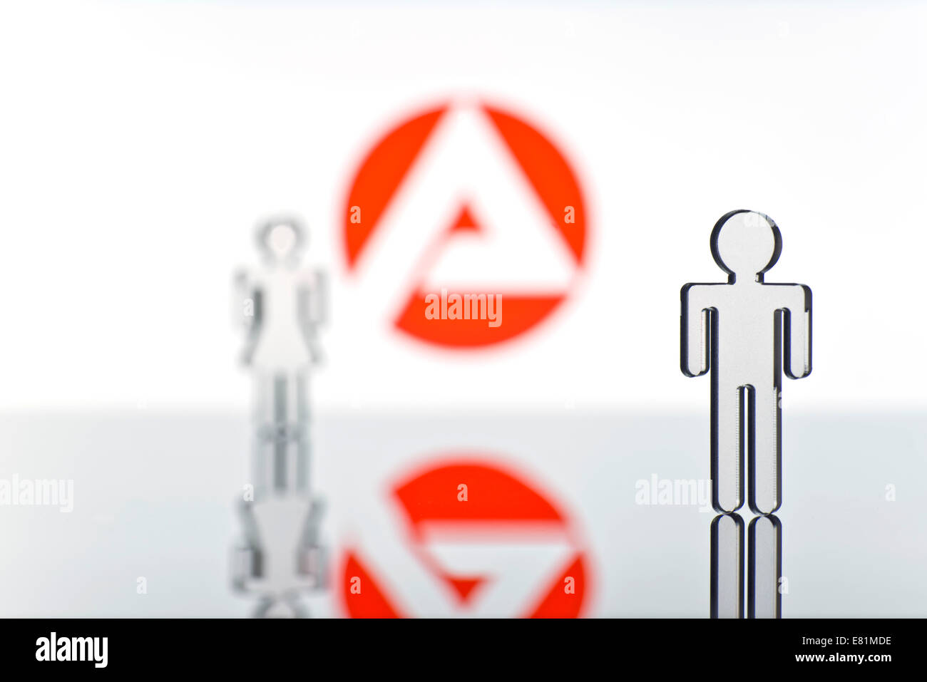 Two figures standing in front of the logo of the German employment ...