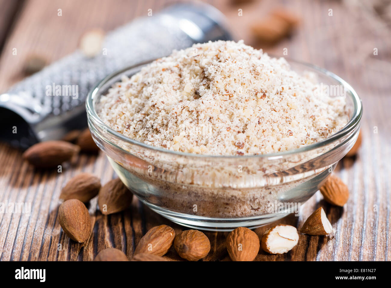 Portion of grated Almonds (detailed close-up shot on wooden background ...
