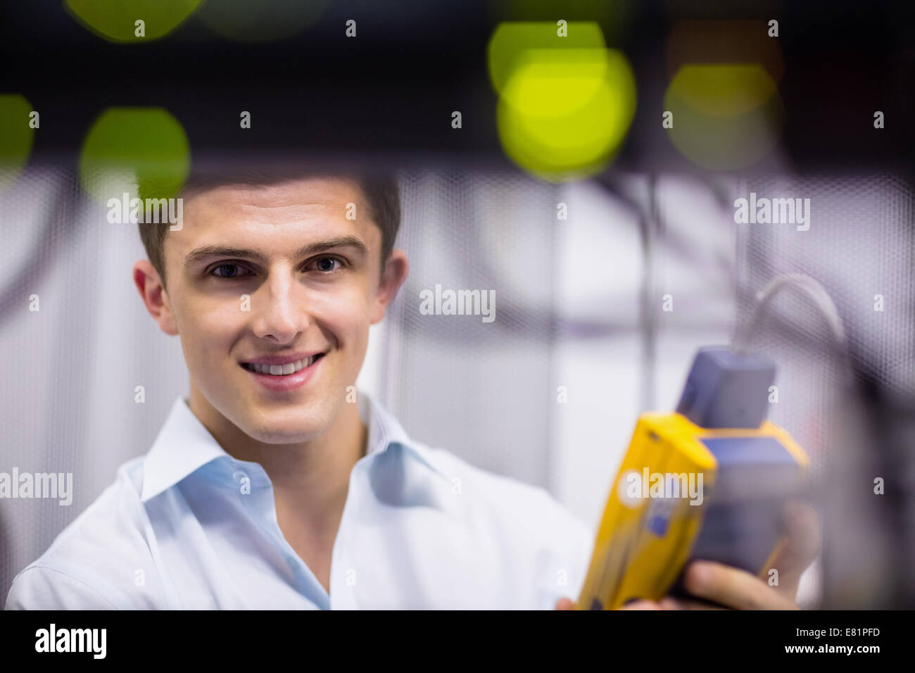 Happy technician using digital cable analyzer on server Stock Photo - Alamy