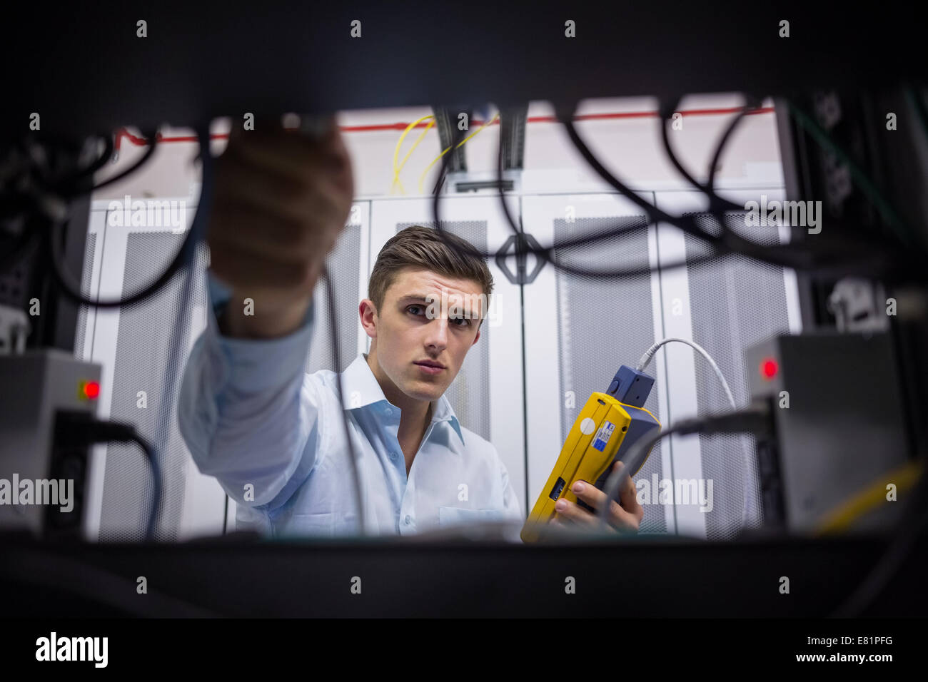 Technician using cable tester while fixing server Stock Photo - Alamy
