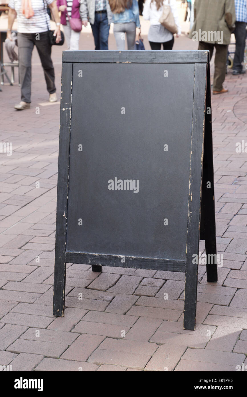 blank blackboard advertising street sign with unrecognizable ...