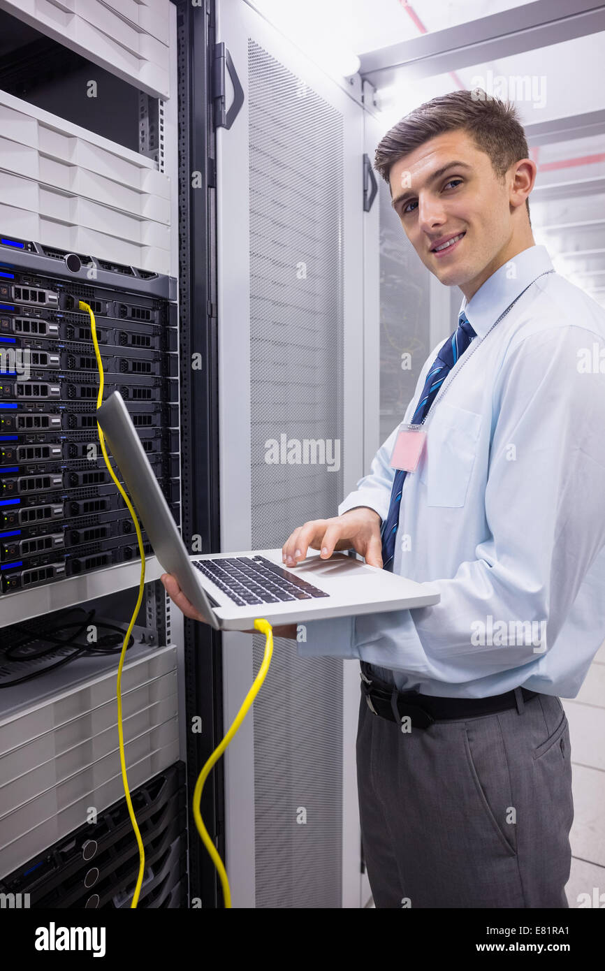Portrait of a technician using laptop while analysing server Stock ...