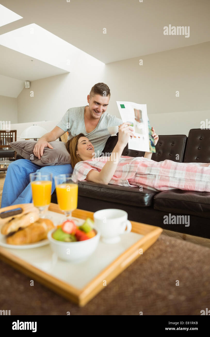 Cute couple relaxing on couch at breakfast Stock Photo - Alamy