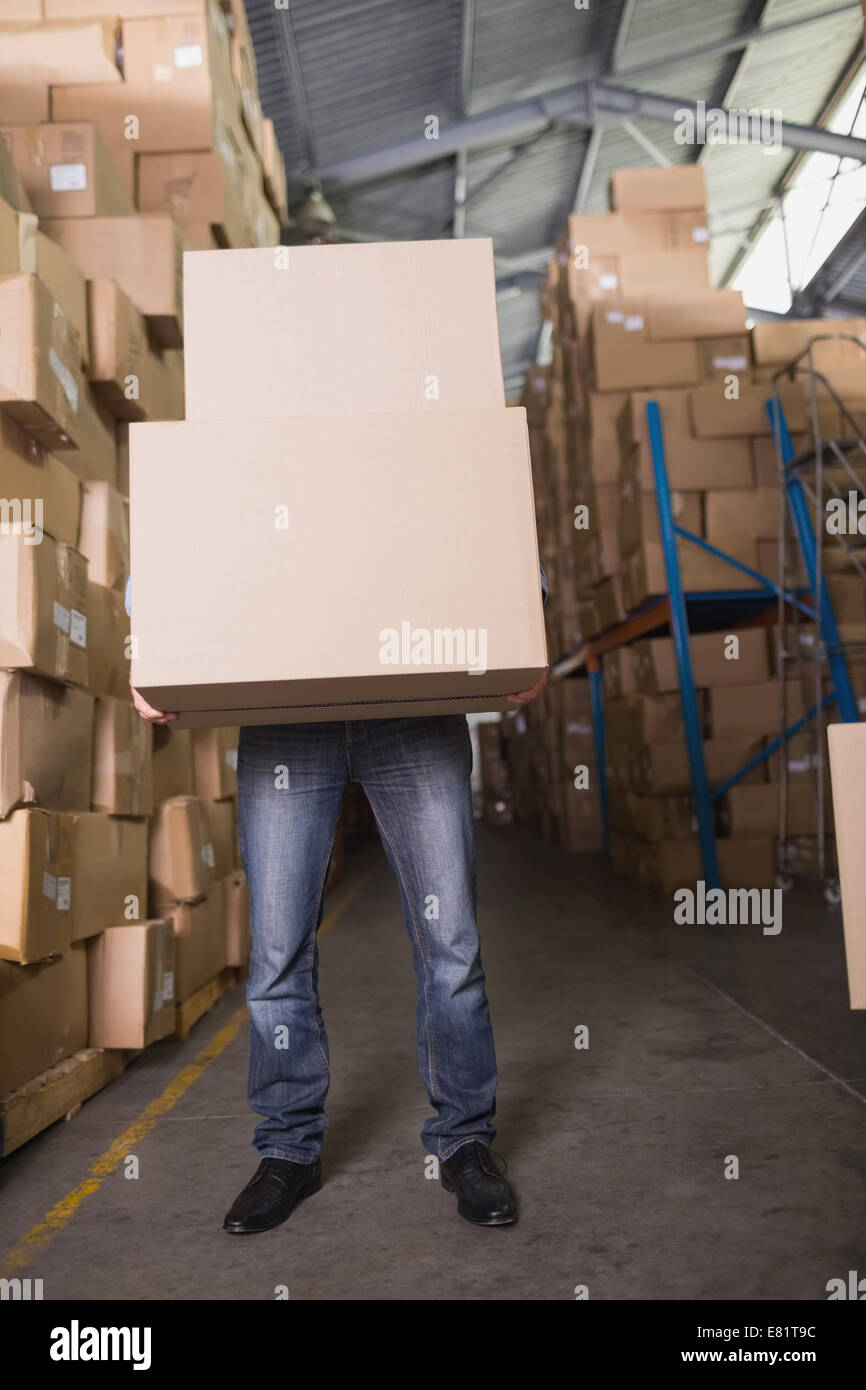 Worker carrying boxes in warehouse Stock Photo - Alamy