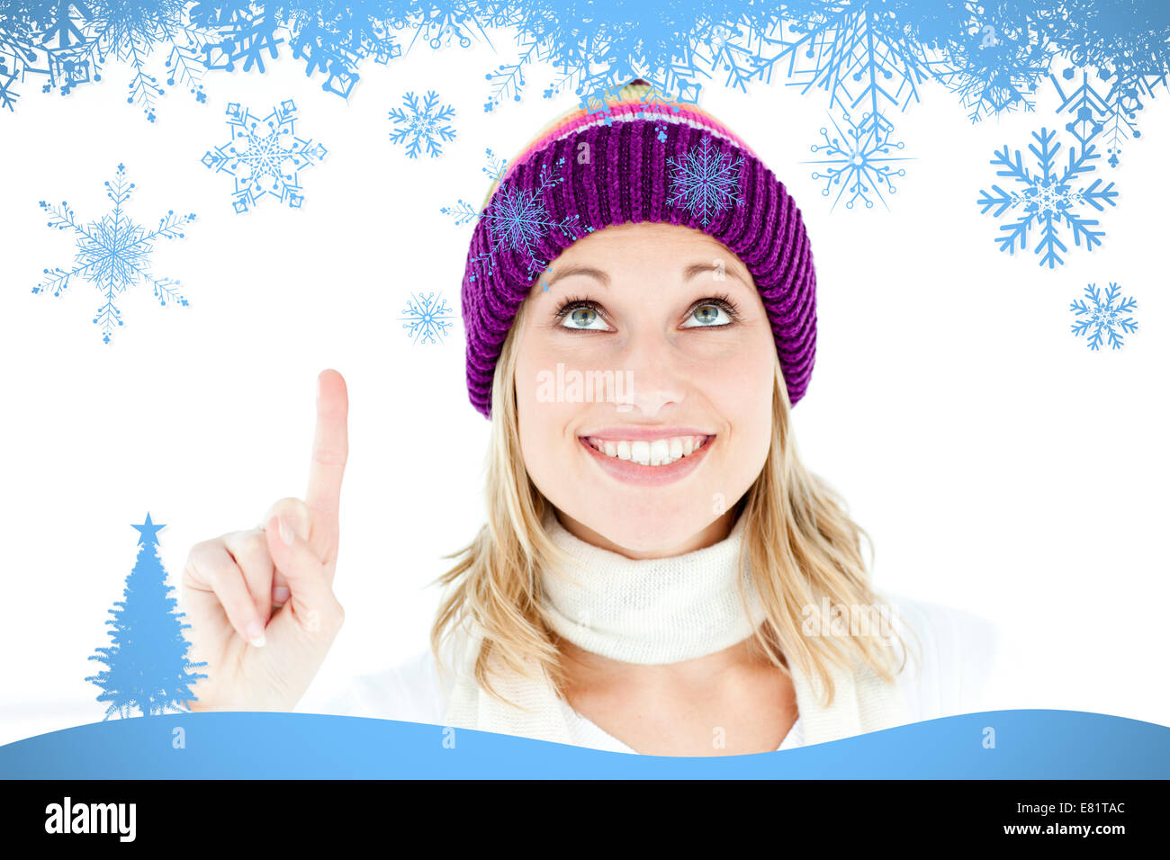 Composite image of bright woman with a colorful hat pointing upwards ...