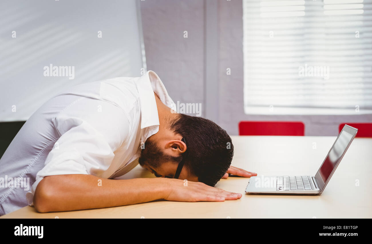 Casual businessman feeling exhausted at his desk Stock Photo - Alamy