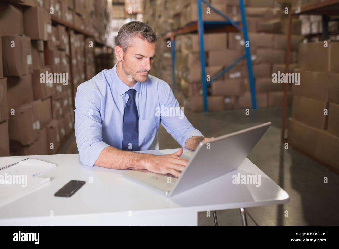 Warehouse manager using laptop Stock Photo - Alamy
