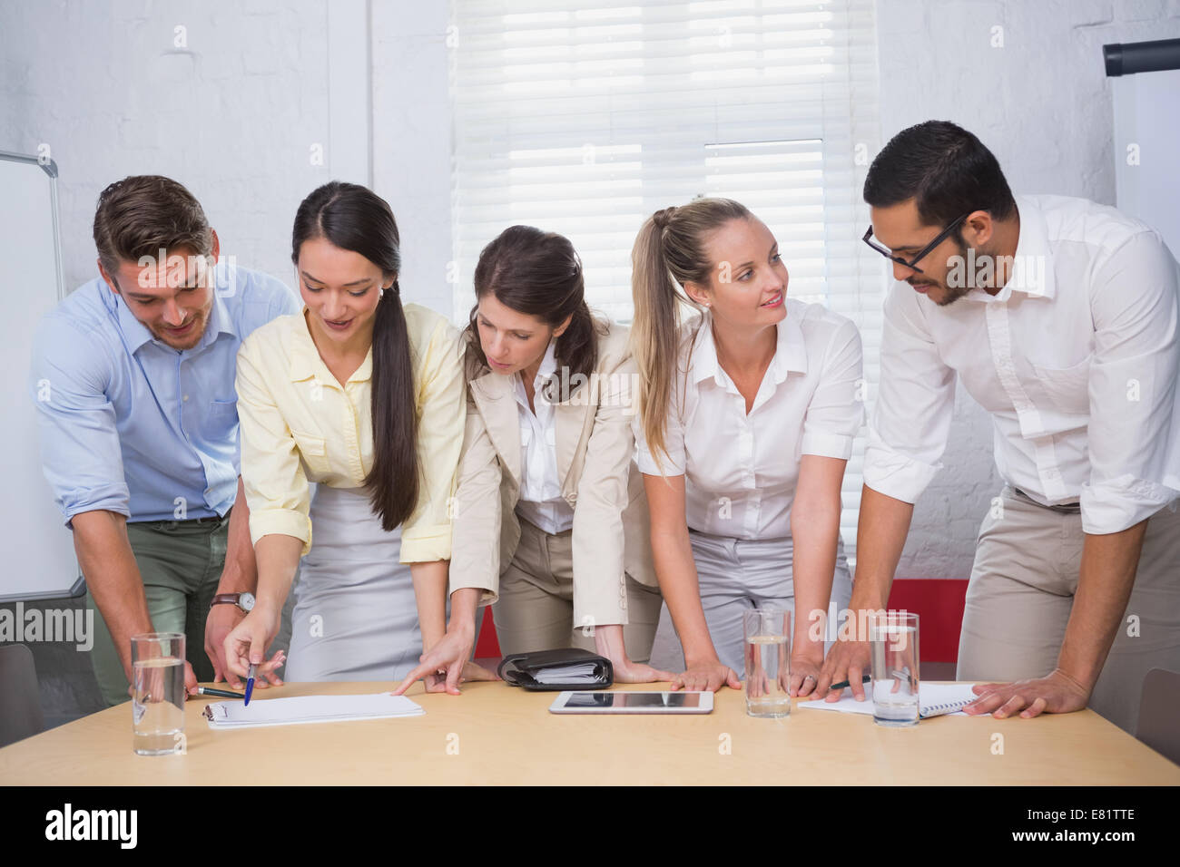 Smiling business people working together on a document Stock Photo - Alamy