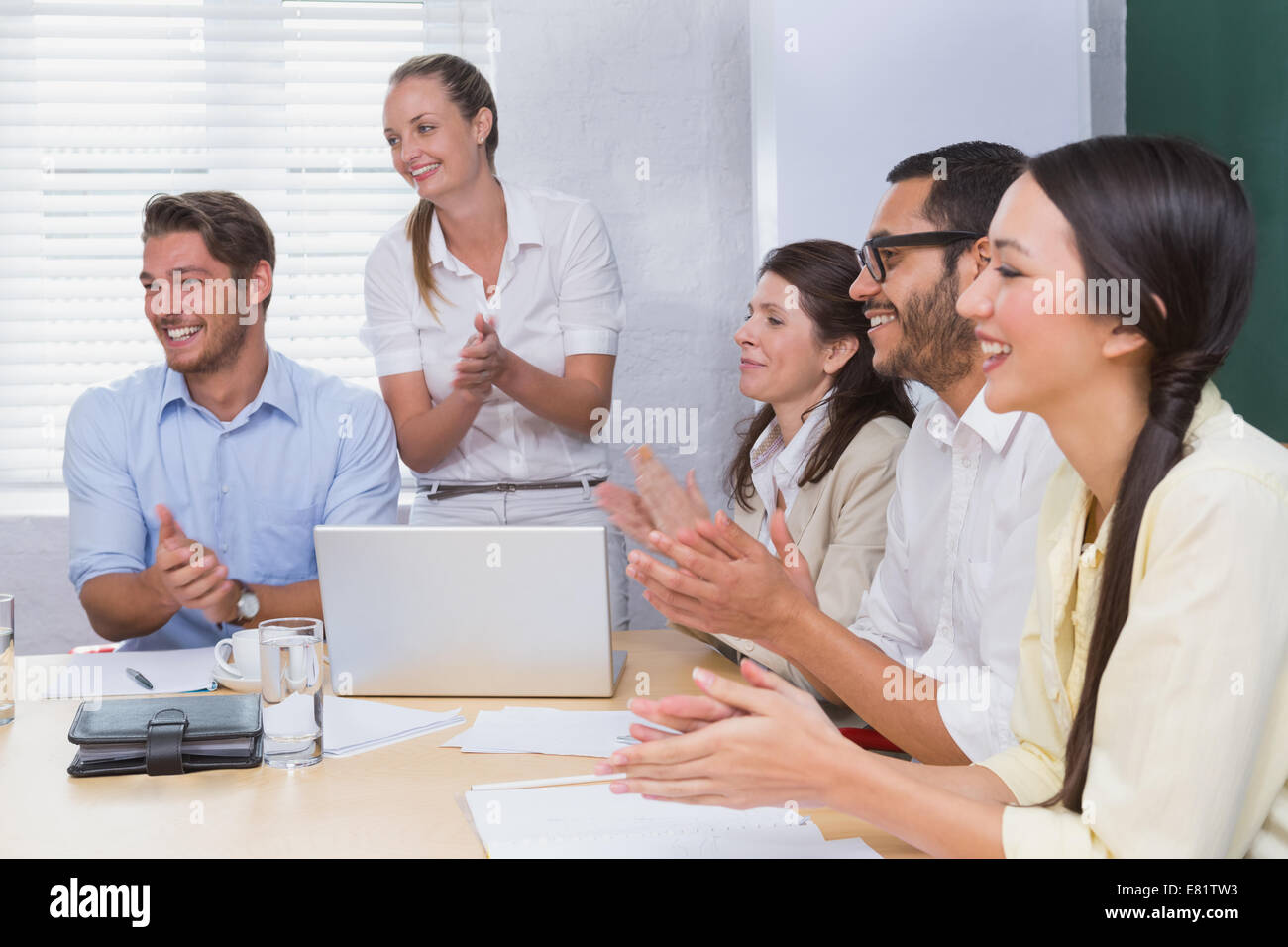 Smiling business people clapping during a meeting Stock Photo - Alamy