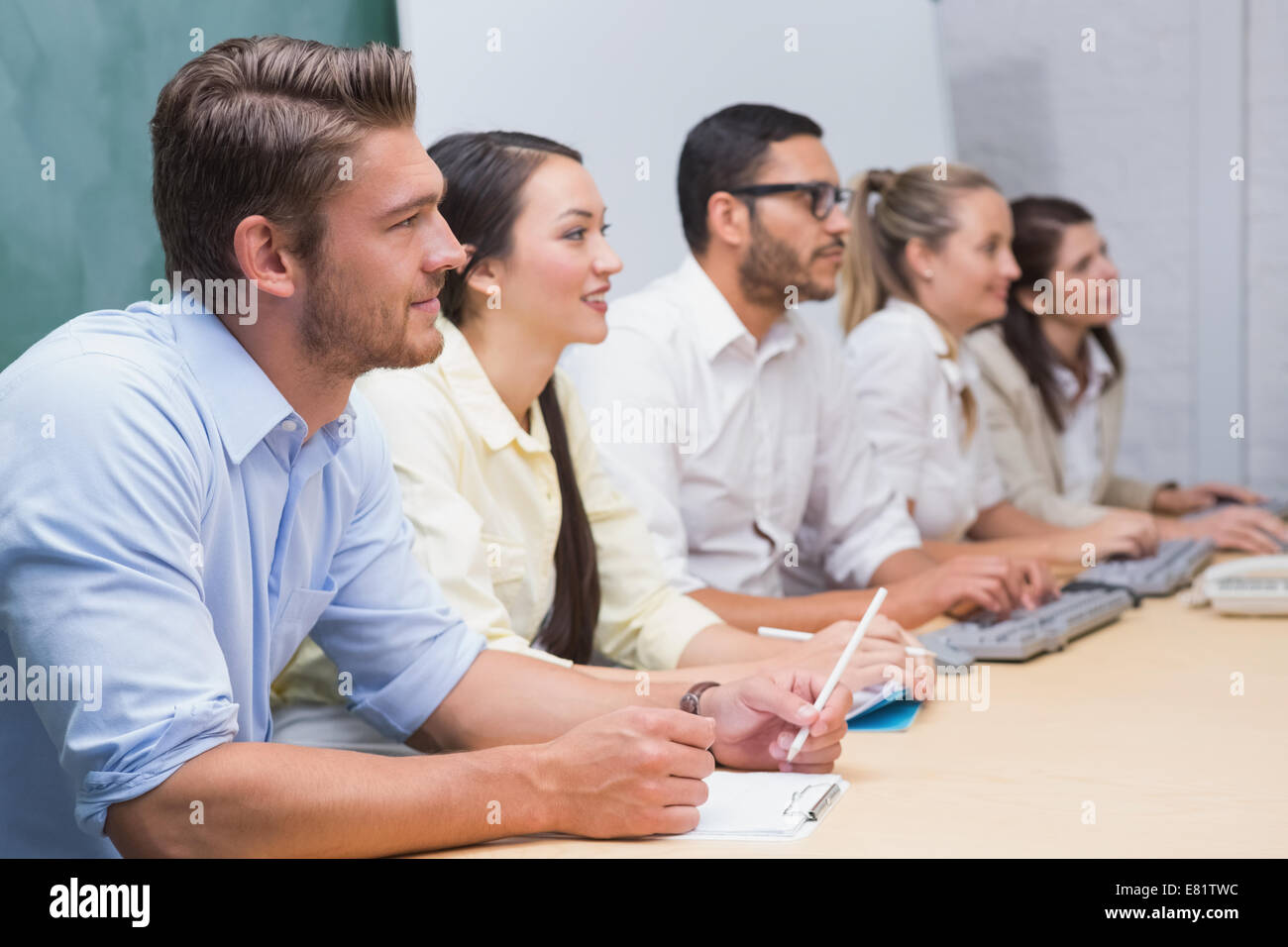 Business team sitting in a line listening during a meeting Stock Photo ...