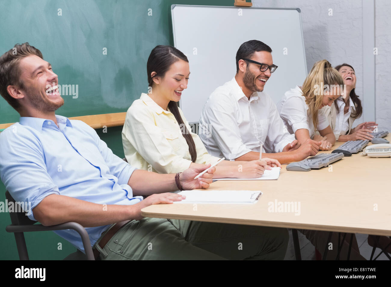 Casual business team laughing during meeting Stock Photo - Alamy