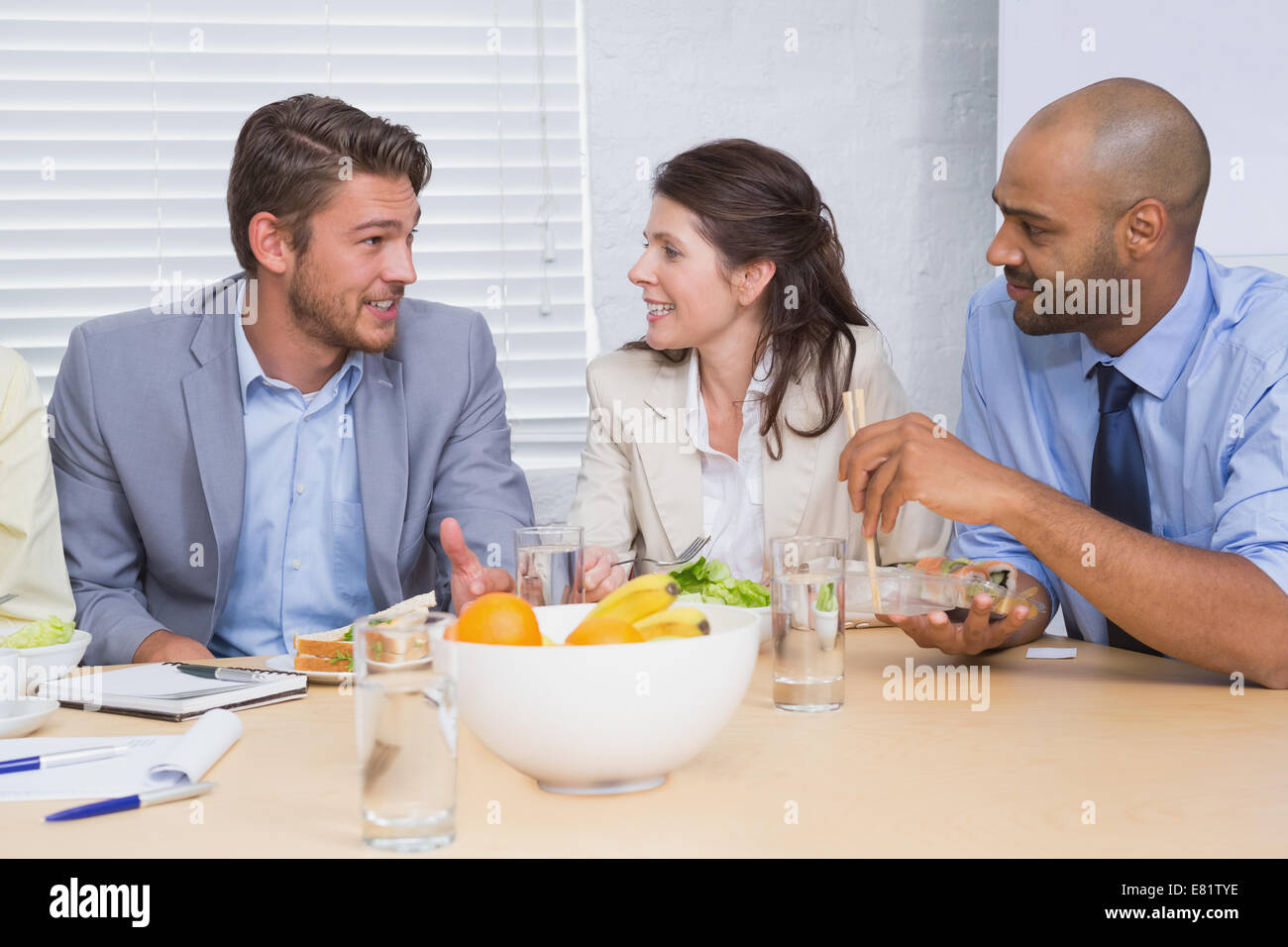 Workers chatting while enjoying healthy lunch Stock Photo - Alamy