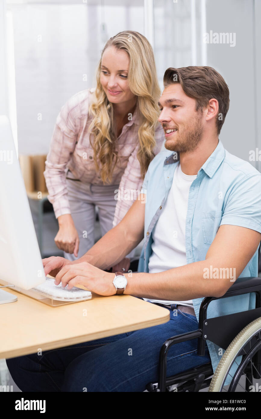 Casual businesswoman helping colleague in wheelchair Stock Photo - Alamy