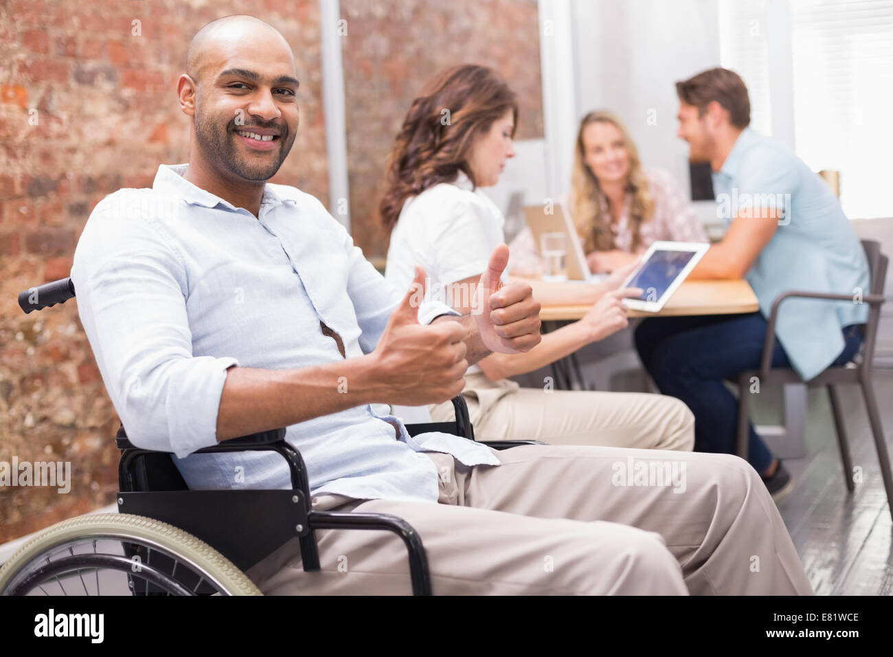 Man in wheelchair smiling at camera giving thumbs up Stock Photo - Alamy