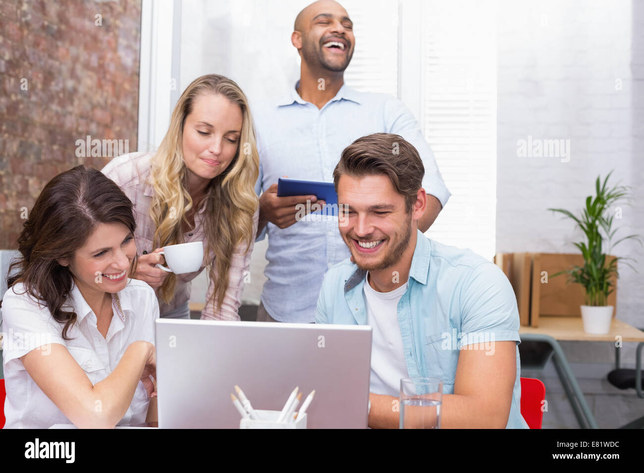 Business team laughing together in front of the laptop Stock Photo - Alamy