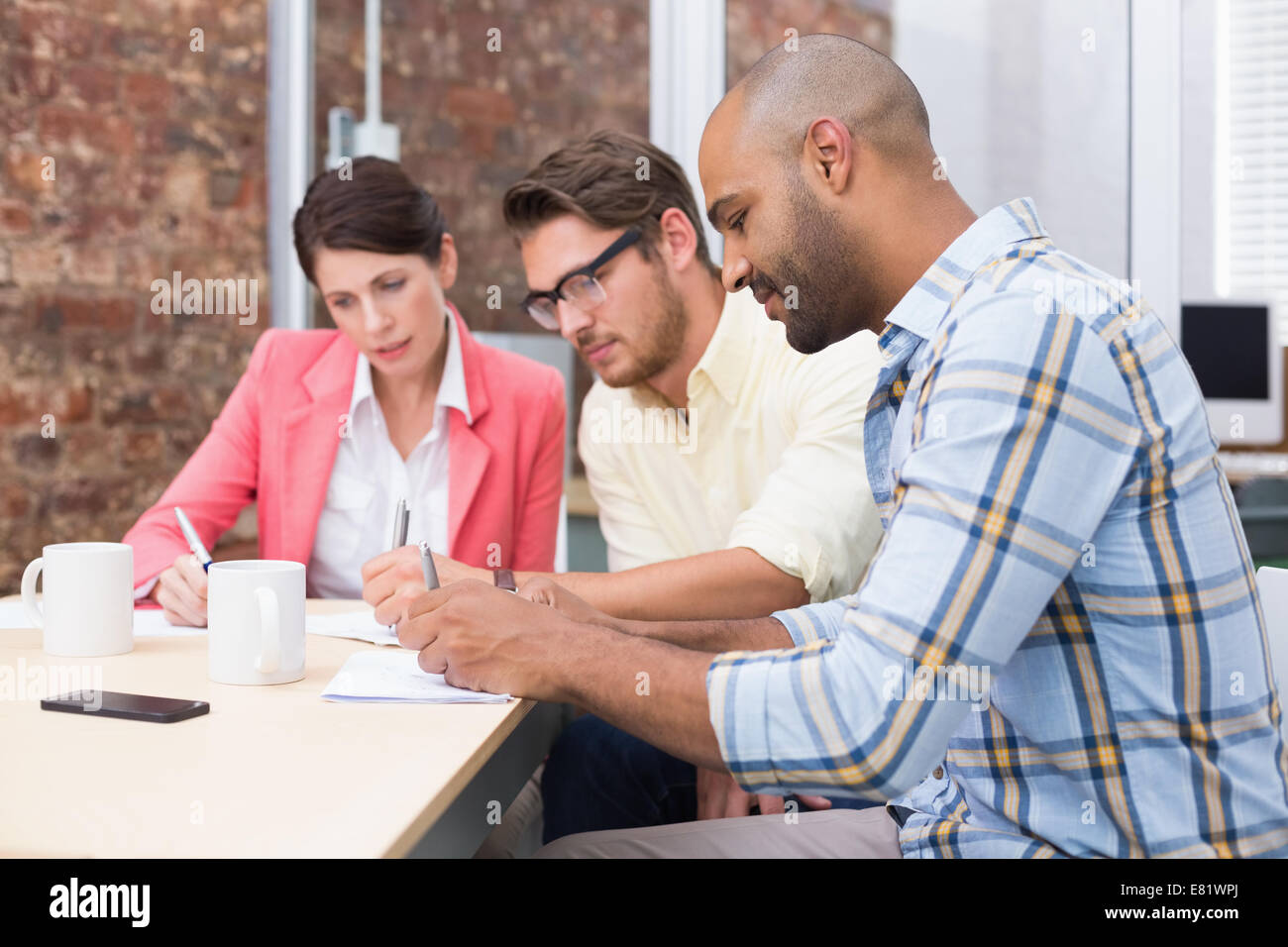 Focused business people taking down important notes Stock Photo - Alamy