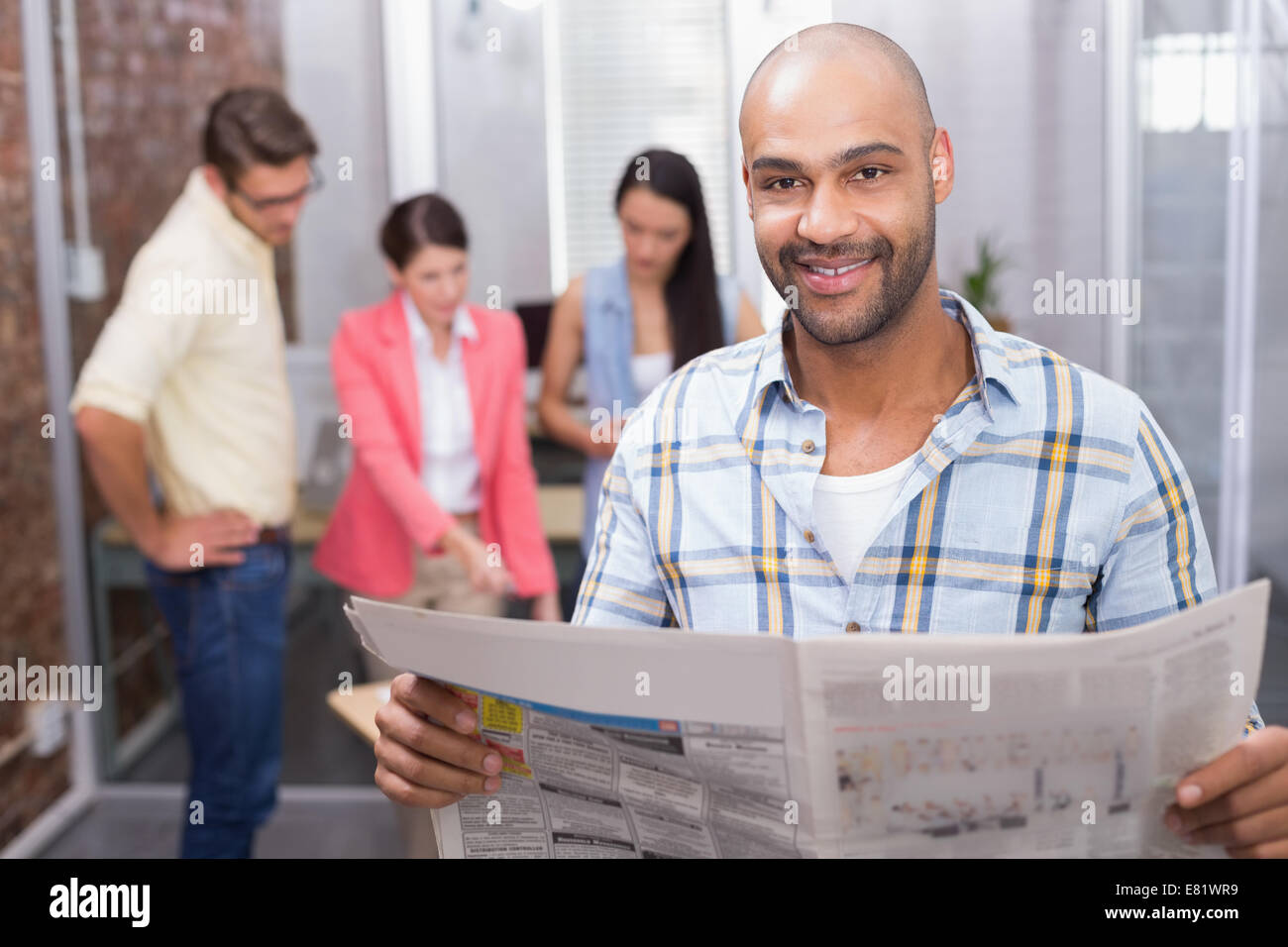 Smiling man reading the newspaper Stock Photo - Alamy