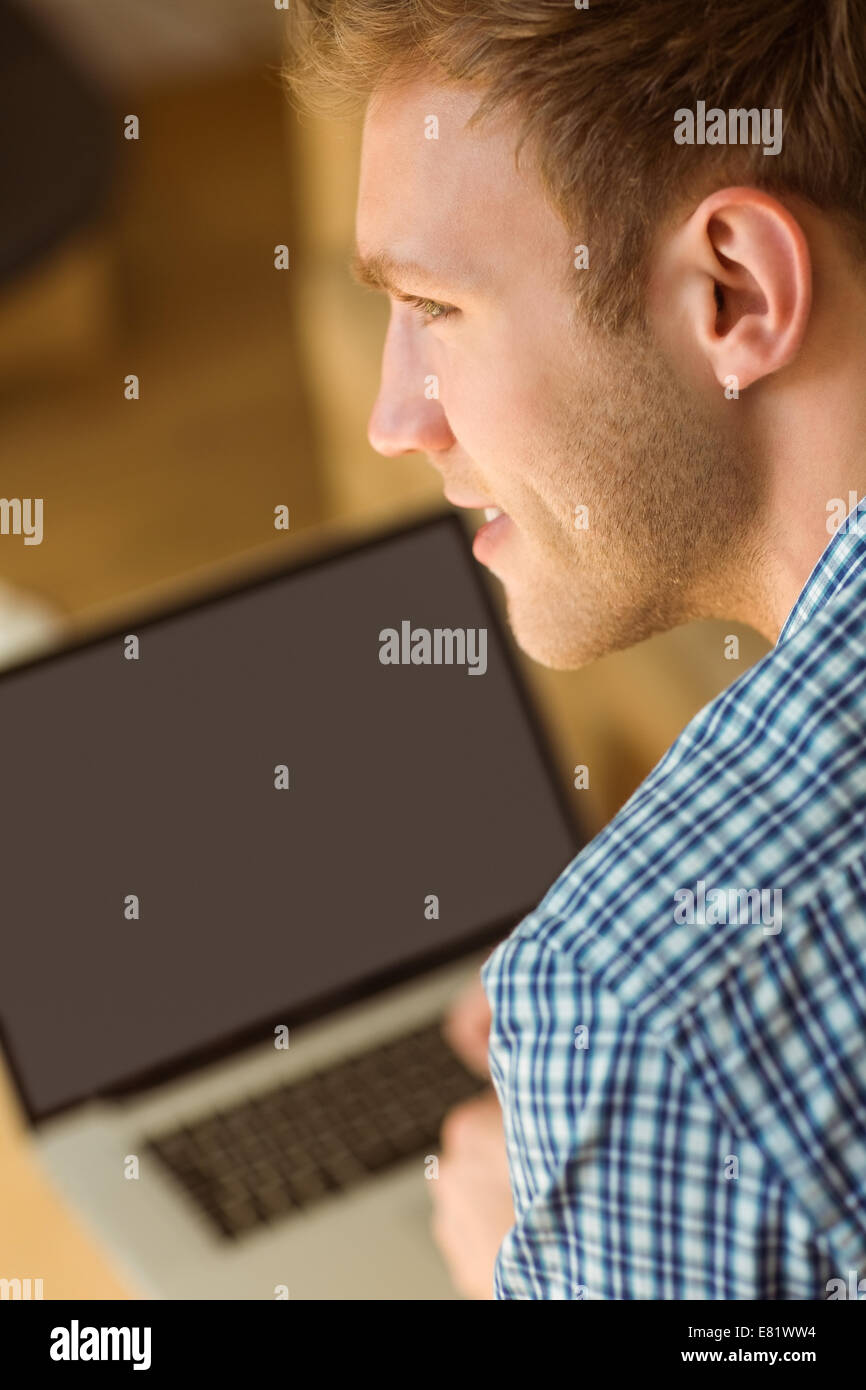 Young man using laptop on his couch Stock Photo - Alamy